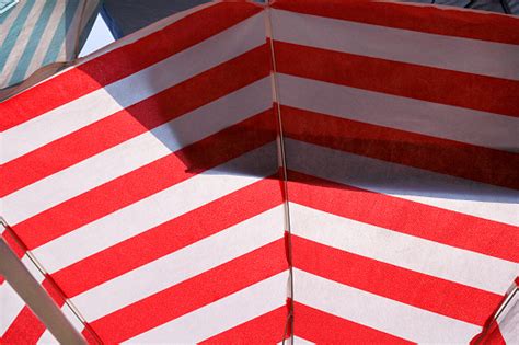 태양 광선 근접 촬영의 일광욕 및 보호를 위한 빨간색과 흰색 태양 우산의 일부 질감 소재 패턴 배경 화려한 파라솔 비치 우산의 벽지 열 대 해변의 휴일 0명에 대한 스톡