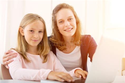 Mulher Que Ajuda Para Fora Sua Irm Mais Nova Para Trabalhos De Casa Foto De Stock Imagem De