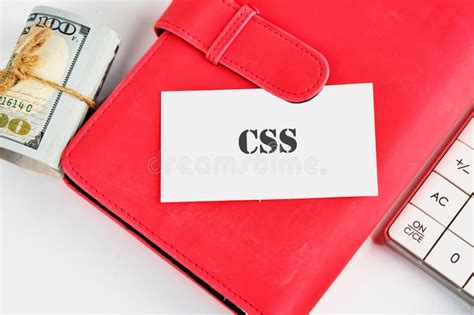 A Red Notebook Displays A Card Labeled Css Next To A Stack Of Cash And A Calculator