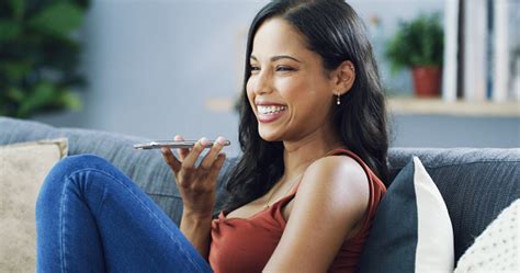 소녀 스피커폰 통화 소파에서 행복하게 거실에서 모바일 네트워킹으로 대화하고 수다를 떨 수 있습니다 사람 여자 그리고 연락을 위해 스마트폰으로 미소 짓고 아파트의 소파에서