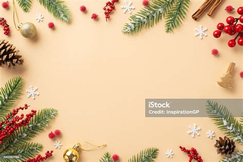 새해 개념입니다 황금 싸구려 가문비 나무 가지의 상위 뷰 사진 흰 서리 소나무 콘 계피 스틱 겨우살이 열매 중간에 빈 공간이 있는 고립된 베이지색 배경에 눈송이 0명에 대한