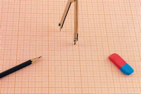 Premium Photo Compass Eraser And A Pencil On A Sheet Of Graph Paper