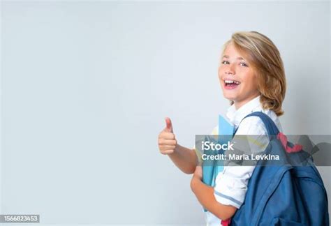 중학교 웃고 있는 십대 소년 소녀 배낭 하얀 배경은 책을 들고 카메라를 들고 엄지손가락을 치켜세운다 빈 개념을 광고하기 위한 공간을 복사합니다 학교로 돌아 가기 어린 시절
