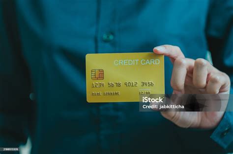 Person Holding Gold Credit Card Showcasing Financial Identity And
