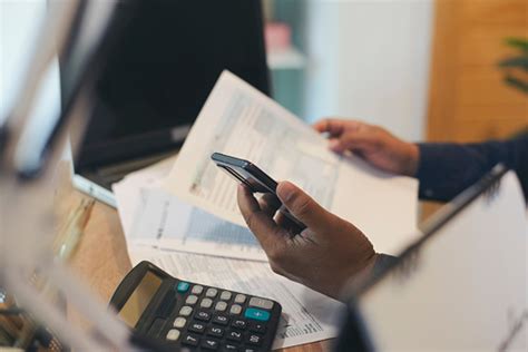 세금 예산 및 세금 계획 개념을 지불하는 계절 사업가 손은 연간 세금을 계산하고 휴대 전화를 사용합니다 계산기 달력 2023 및