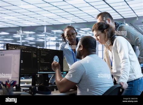 Team Of Engineers Working In Server Farm Using Pcs To Analyze Data