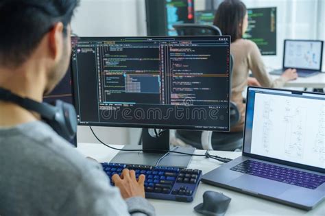 Asian Software Developers Working On Multiple Screens Displaying Code
