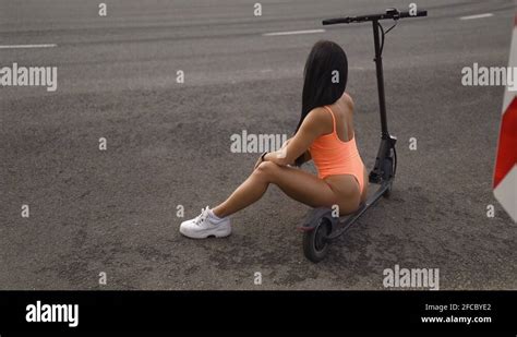 Sexy Hot Woman Sitting Electric Scooter At Parking Lot Wearing Body Swimwear Stock Video Footage