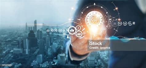 기어와 톱니바퀴가 달린 전구를 들고 있는 사업가 글로벌 네트워크 연결에 대한 비즈니스 및 공정 워크플로우의 창의성 혁신적인 솔루션 분석 및 개발 콘텐츠의 상징적 영감에 대한