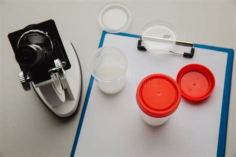 A Plastic Cup With Sperm For Semen Analysis On The Doctorand X27s Table