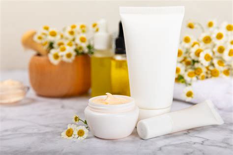 카모마일 스파 카모마일 꽃 수제 비누 에센셜 오일 화장품 병 바디 크림 스크럽 및 바다 소금이 흰색 질감 배경에 있습니다 편안한 뷰티 트리트먼트 복사 공간 건강관리와 의술에