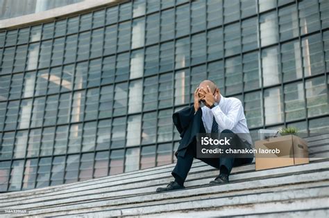 슬픔은 일자리를 잃은 후 개인 물품을 포장하는 상자 골판지로 우울한 사업가 건물 앞 계단에 앉아 있는 실패한 사업가 해고된 실업자 실업자 위기 걱정하는에 대한 스톡 사진 및