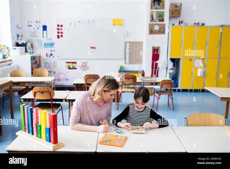 Teacher Using Geoboard In Class Teaching Students Explaining Geometry