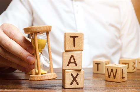 말 세와 나무 블록 근처에 모래 시계를 들고 사업가의 손 세금을 납부 할 시간 연례 과세의 개념 차량 부동산 구매 럭셔리에 대 한 세금 주 수수료 가계에 대한 스톡 사진 및