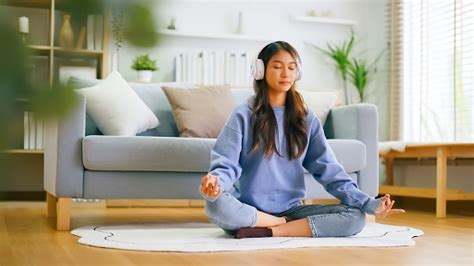 행복한 젊은 아시아 여성들은 집에서 요가와 명상을 연습하고 연꽃 자세로 거실 바닥에 앉아 눈을 감고 휴식을 취한다 마음챙김