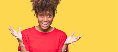 미친을 축 하 하 고 무기와 성공을 위한 흥분 비명 제기 및 오픈 눈 깜짝 놀라게 격리 된 배경 위에 아름 다운 젊은 아프리카계 미국인 여자 우승자 개념 T 셔츠에 대한