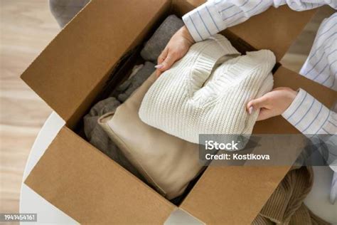 골판지 상자에 따뜻한 중성 스웨터를 넣는 여성 손 계절 보관 방법 및 기부 자선기부에 대한 스톡 사진 및 기타 이미지 자선기부 의류 기부함 Istock