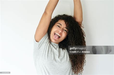 Portrait Of Woman Sticking Out Her Tongue On White Background High Res