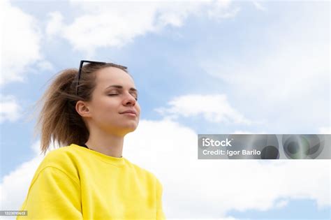 솔직한 매력적인 젊은 여성은 삶과 순간을 즐기는 눈을 감고 높은 푸른 하늘 아래에 서 있습니다 복사 공간이있는 하늘 배경의 여성 초상화 기쁨 생활 개념 개성 개념에 대한