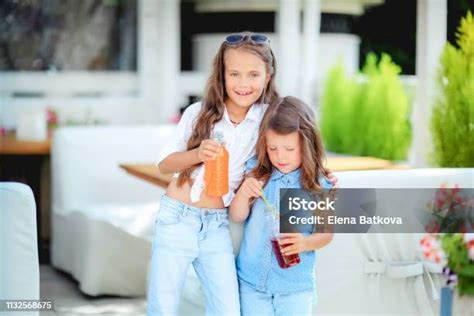 거리 카페에서 함께 딸기 스무디 주스를 마시는 친절 한 아이 소녀와 재미 있는 감정 어머니는 서로를 보고 근접 촬영 초상화