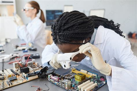 Portrait Of Black Of Female Engineer Inspecting Computer Parts In Quality Control Lab Stock