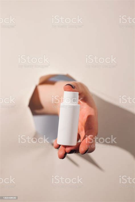 한 여성의 손이 화장품 튜브를 들고 종이에 구멍을 뚫고 나눕다 뷰티 컨셉 복사 공간 건강한 생활방식에 대한 스톡 사진 및 기타 이미지 건강한 생활방식 공란 그림자