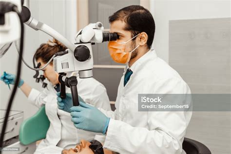 두 명의 치과 의사가 환자를 치료합니다 전문 유니폼 과 치과 의사의 장비 의사의 직장을 갖추는 의료 서비스 치과 거울에 대한
