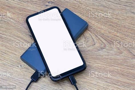 휴대용 충전기는 나무 테이블에 스마트 폰을 충전합니다 흰색 화면과 전원 은행과 휴대 전화 모형 Usb 케이블에 대한 스톡 사진 및 기타 이미지 Istock