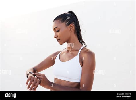 Fitness Female In White Sports Attire Adjusting Smartwatch Before A Workout Woman Checking