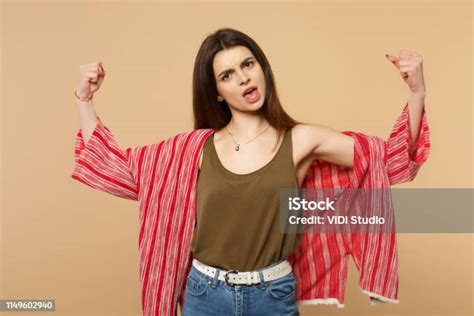 캐주얼에 강한 젊은 여자의 초상화 손을 확산이 두 근을 보여주는 스튜디오에서 파스텔 베이 지 배경에 고립 된 근육 사람들은 진심으로 감정 라이프 스타일 개념입니다 복사