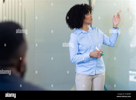 presenting data on whiteboard businesswoman explaining graph in