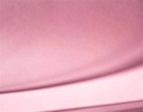 그림자와 빛이 전면에 초점을 맞춘 분홍색 곡선 종이 배경 프리미엄 사진