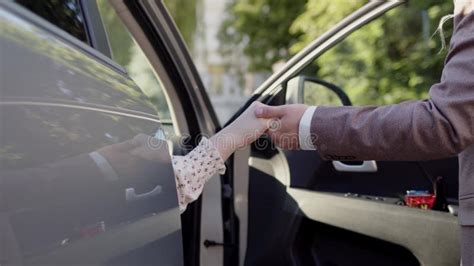 Joven Novio Ayuda A Su Novia A Entrar En Un Coche Gris Hombre Abre La Puerta A Una Mujer Con