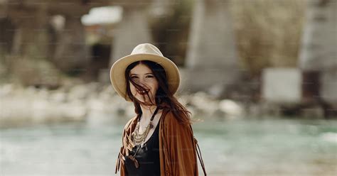 모자 프린지 판초 부츠를 신고 강 해변을 걷는 세련된 힙스터 여성 보헤미안 여행자 소녀 집시 모습 여름 여행 대기 순간 텍스트 공간 사진 Unsplash의