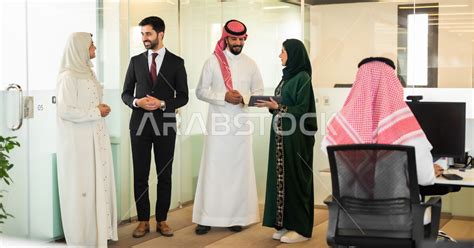 مناقشة وتنظيم العمل بين موظفين عرب خليجيين سعوديين في غرفة الاجتماعات