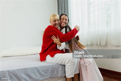 화창한 오후 밝고 아늑한 실내에서 서로를 기쁘게 껴안고 따뜻함과 애정을 표현하는 두 여성 2명에 대한 스톡 사진 및 기타 이미지