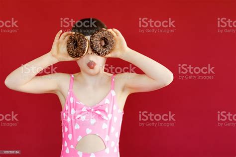 고무 반지와 그녀의 손에 도넛을 들고 스튜디오에서 포즈 와 수영복에 매력적인 어린 소녀의 고립 된 샷 수영 풍선 원을 들고 예쁜 여성 아이 도넛에 대한 스톡 사진 및 기타