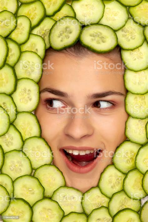 젊은 아름다운 행복한 여자 포즈 와 조각 의 오이 주위에 그녀의 얼굴 가꿔주기에 대한 스톡 사진 및 기타 이미지 가꿔주기