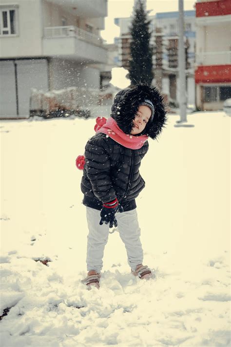 목에 빨간 스카프를 두르고 눈 속에 서 있는 어린 소녀 사진 Unsplash의 무료 카흐타 이미지