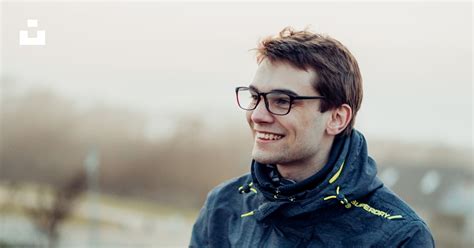 파란색 재킷과 검은색 안경을 쓴 남자가 낮 동안 회색 콘크리트 포장 도로에 앉아 있다 사진 Unsplash의 무료 클림핑 비치 이미지