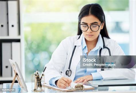 병원에서 진단을 위해 환자 기록을 작성하는 여성의 의사 보험 및 의료 사무실에서 건강과 웰빙을위한 클립 보드가있는 종이에 글을 쓰는 의료 종사자 또는 간호사 20 24세에