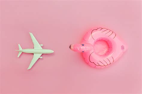 여름 해변 구성입니다 파스텔 핑크 배경에 고립 된 비행기와 팽창식 플라밍고최소한의 간단한 평신도 휴가 여행 모험 여행 개념입니다