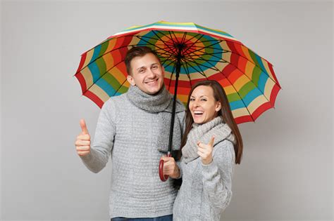 회색 벽 배경 스튜디오 초상화에 고립 된 우산 아래 함께 회색 스웨터 스카프에 커플 여자 사람입니다 건강 한 생활 습관 병 아픈 질병 치료 추운 계절 개념 복사 공간을 모의