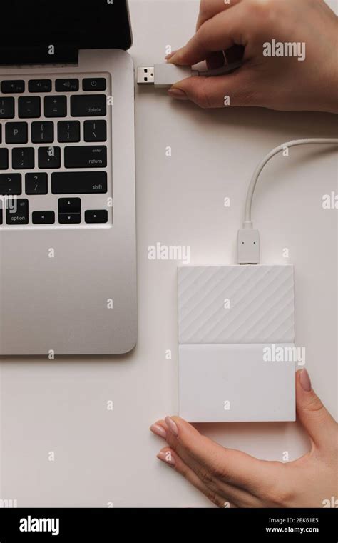 Female Hand Connected Portable Hard Drive To Laptop For Data Transfer Backup Files Copy File