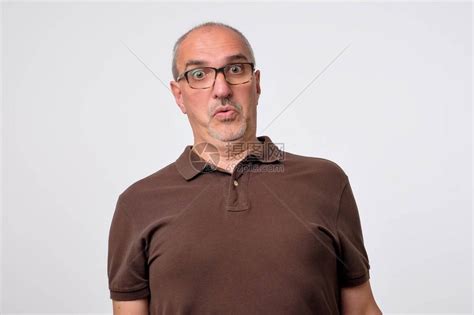 灰色背景上身穿棕色衬衫的白种人成熟男人震惊的脸他注意到一个非常漂亮的女人高清图片下载 正版图片505381768 摄图网