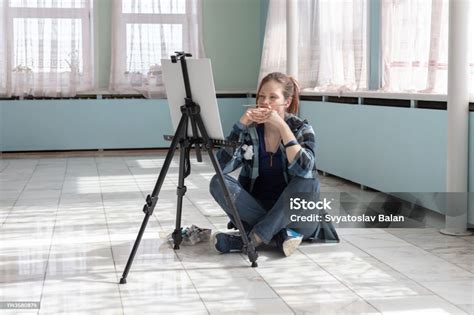 소녀 예술가 대리석 바닥에 앉아 기름 물감으로 페인트 흰색 캔버스와이 젤은 청록색과 밝은 녹색 벽과 함께 방에 대리석 타일의 바닥에 서 있다 개념에 대한 스톡 사진 및 기타