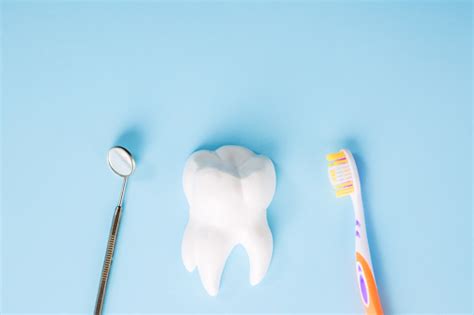 화이트 치아 모델 및 공간이 밝은 파란색 배경에 칫 솔 전문 치과 거울 치과 건강 및 Teethcare 개념입니다 강철에 대한