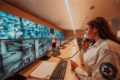 Female Security Guard Operator Talking On The Phone While Working At