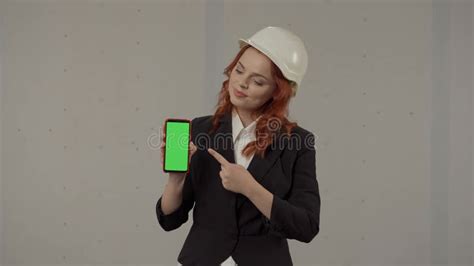 A Female Architect Is Holding Smartphone Screen Facing Forward Pointing At Its Green Screen And
