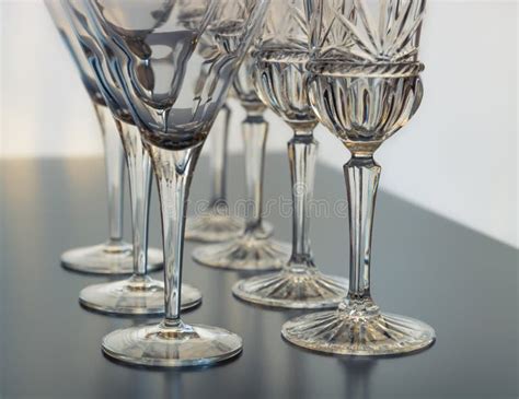 Wine And Martini Glasses Set Up In Verticle Rows On A Reflective Table